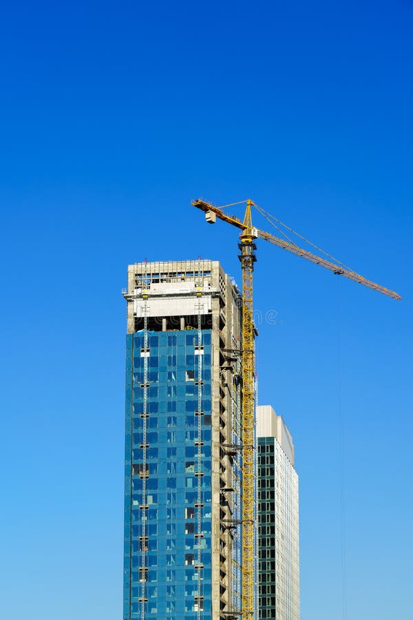 A Crane Building a Skyscraper Against a Blue Sky. Stock Photo - Image ...