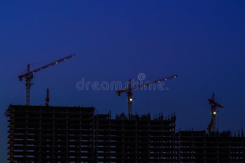 A Crane Building a Skyscraper Against a Night Blue Sky. Stock Photo ...