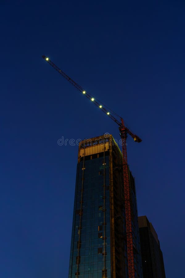 A Crane Building a Skyscraper Against a Night Blue Sky. Stock Photo ...