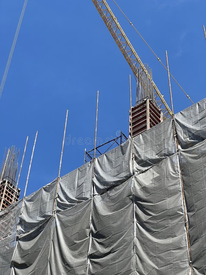 Crane and Building Under Construction Against Blue Sky Stock Photo ...