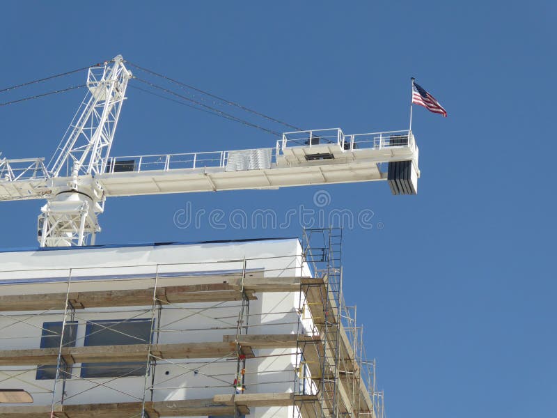 Crane at construction site stock image. Image of flag - 88201931