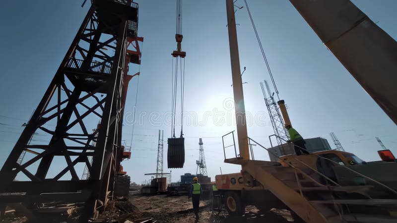 Crane Lifting Heavy Load on Construction Site with Backlit Sun Stock ...