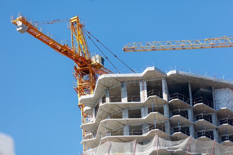 A Crane is Lifting a Large Object Above a Building Stock Photo - Image ...
