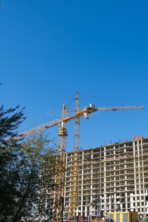 A Crane is Lifting a Large Object in Front of a Building Stock Image ...