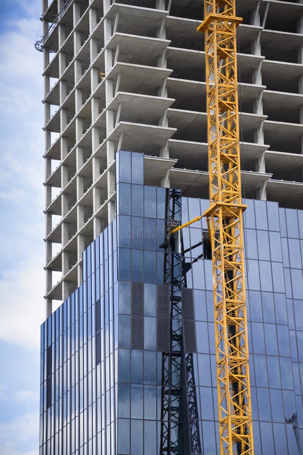 Crane on Skyscraper Construction Site with Windows Reflecting Sky Stock ...