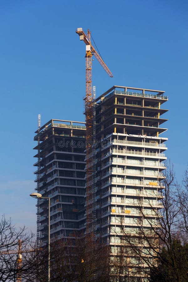 Crane on Skyscraper Construction Site with Windows Reflecting Sky Stock ...