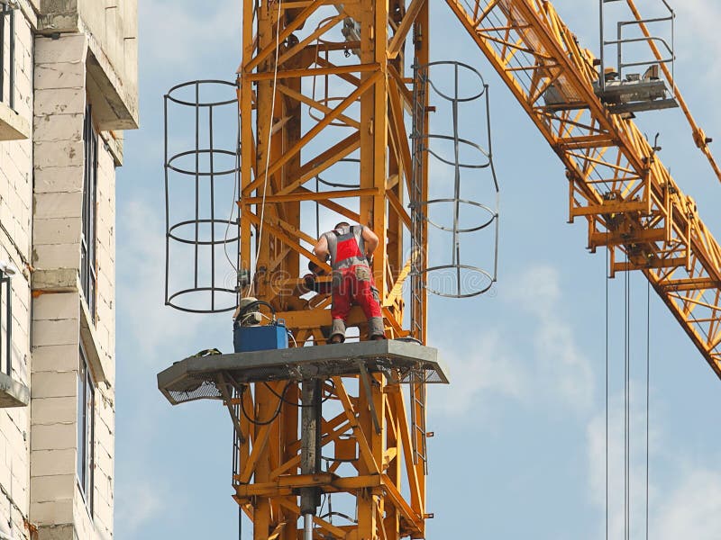 Crane Workers in Overalls are Repairing a High-rise Tower Crane Working ...