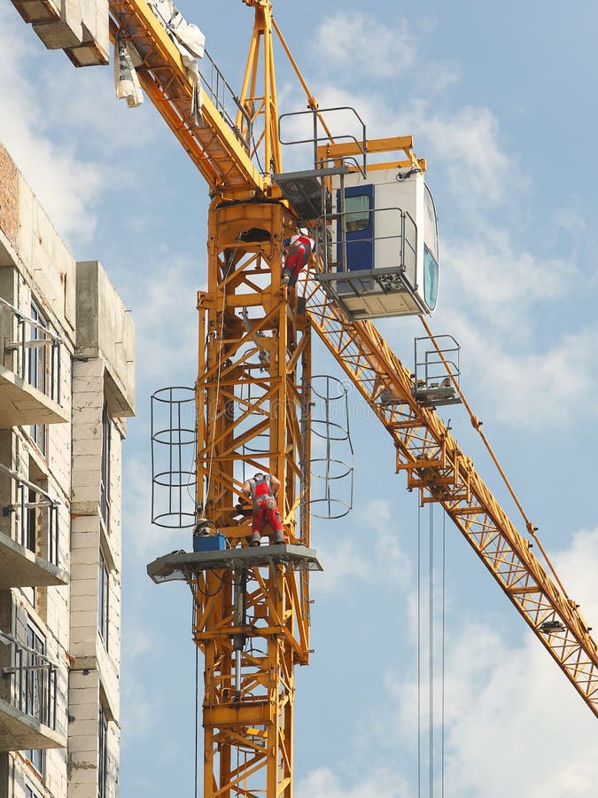Crane Workers in Overalls are Repairing a High-rise Tower Crane Working ...
