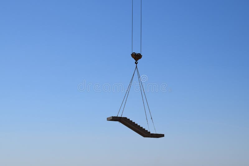 A Crane is Working Against the Blue Sky. Raising Stairs. Stock Photo ...
