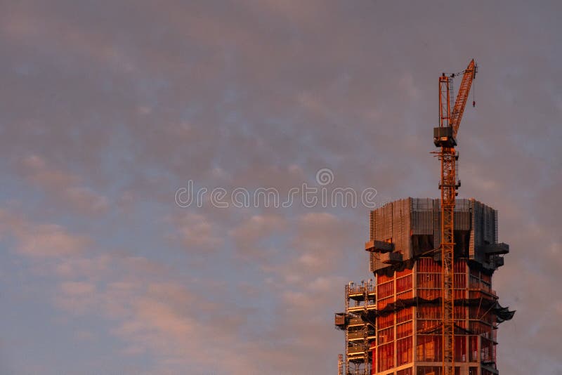 Crane Working on a Super Tall Skyscraper at Golden Hour Stock Image ...