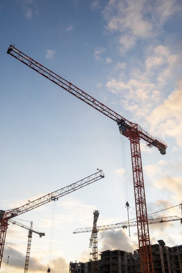Cranes are Actively Positioned at a Construction Site during Sunset ...