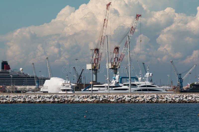 Cranes at Work in Boatyard Near Lighthouse Stock Photo - Image of ...
