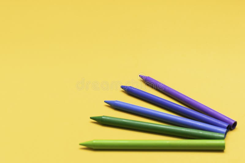 Crayons of Complementary Colors on a Bright Yellow Background Stock ...