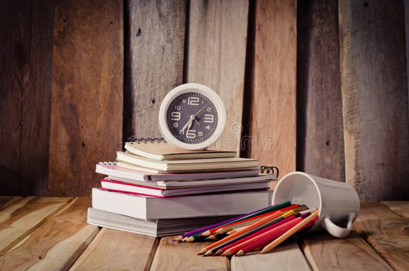 Crayons Stack of Books and Clock on Desk a Wooden Floor Stock Photo ...
