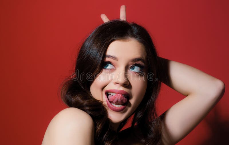 Young Woman Doing Funny Gesture with Finger Over Head As Bull Horns ... Young Woman Doing Funny Gesture with Finger Over Head As Bull Horns ...