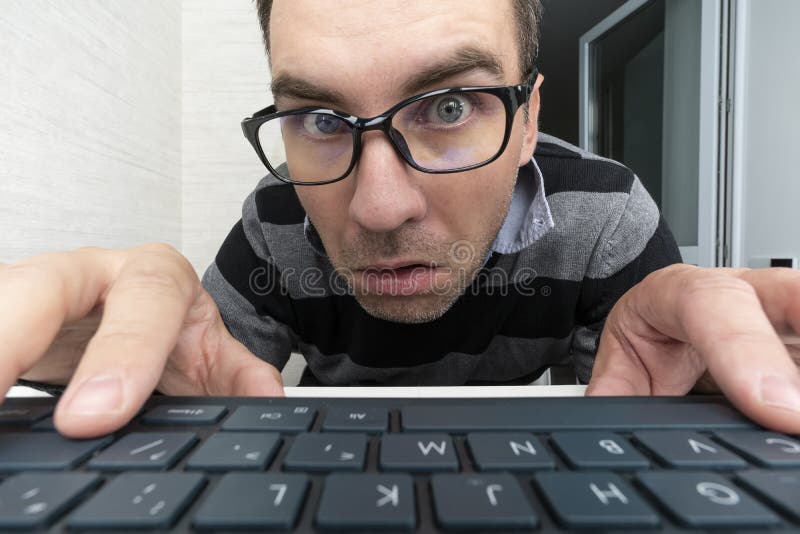 Crazy Looking Man Typing on the Keyboard and Looks at Camera. Surprised ...