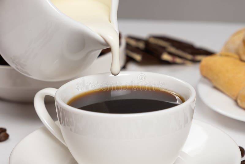 Cream from the Milk Jug is Poured into Coffee, Making Coffee with Cream ...