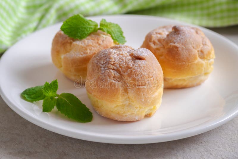 Cream puffs on green plate stock image. Image of eclair - 42254385