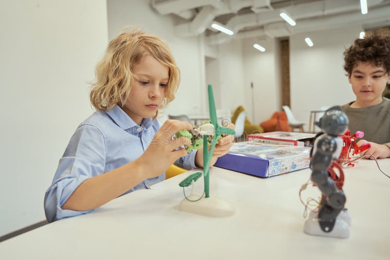 Create Things. Caucasian Boy Examining Technical Toy while Sitting at ...
