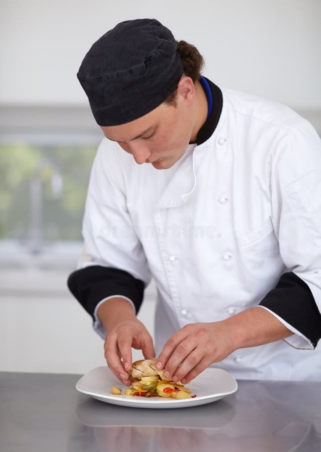 Creating a Culinary Masterpiece. Young Chef Preparing a Chicken Dish in ...