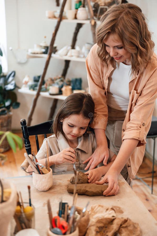 Creating the Shape by Using Clay. Mother with Little Girl Doing Pottery ...