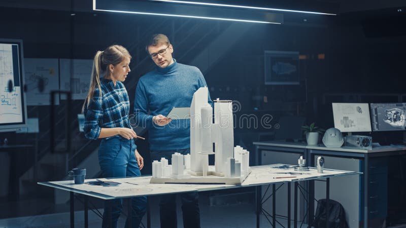 In the Creative Architectural Bureau Two Professional Engineers Work on a Model of a City ...