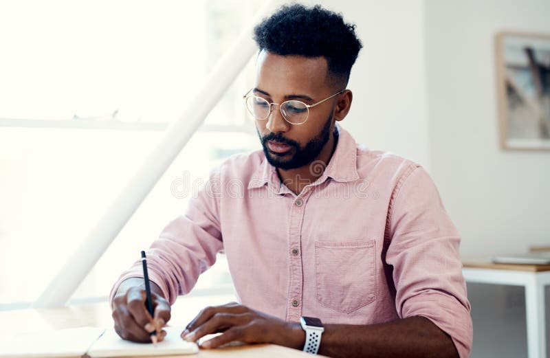 Creative, Black Man and Writing on Book in Office with Notes of ...