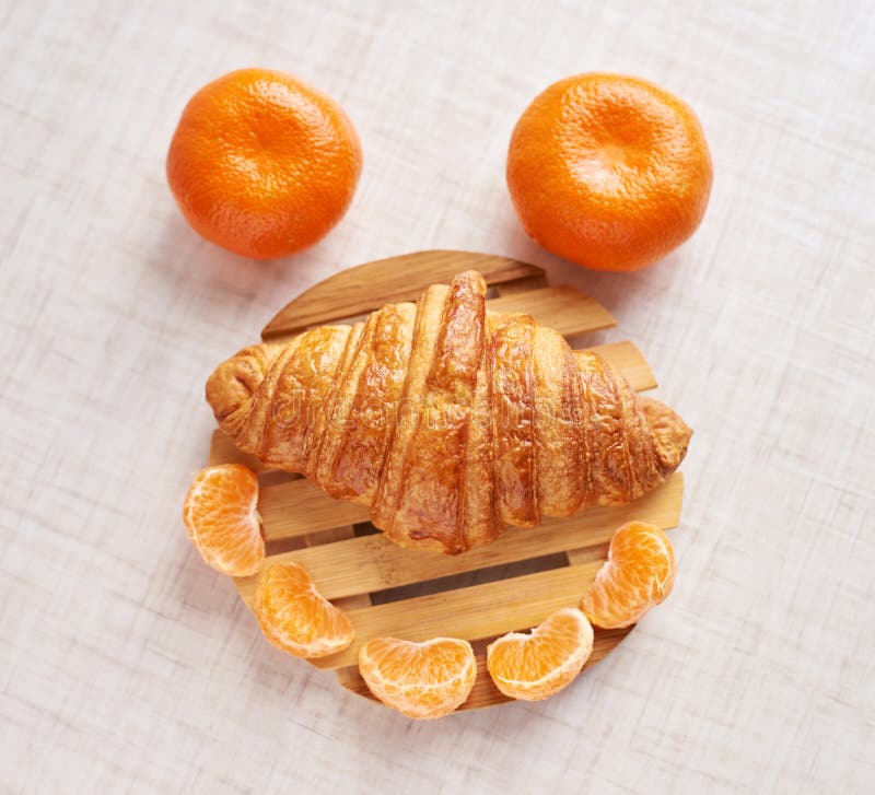 Creative Breakfast Arrangement with Croissant and Tangerines Forming a ...