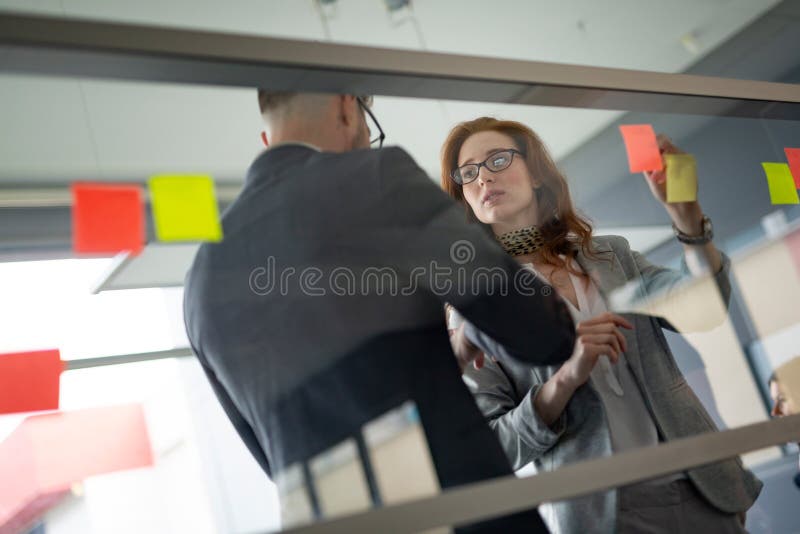 Creative Business Team Looking at Sticky Notes on Window Stock Photo ...