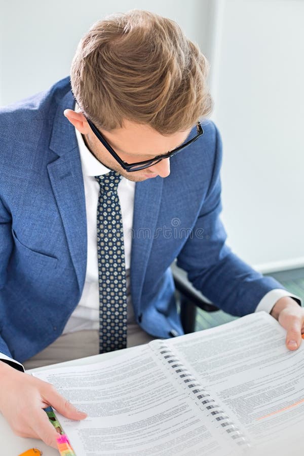 Creative Businessman Reading File at Desk in Office Stock Photo - Image ...