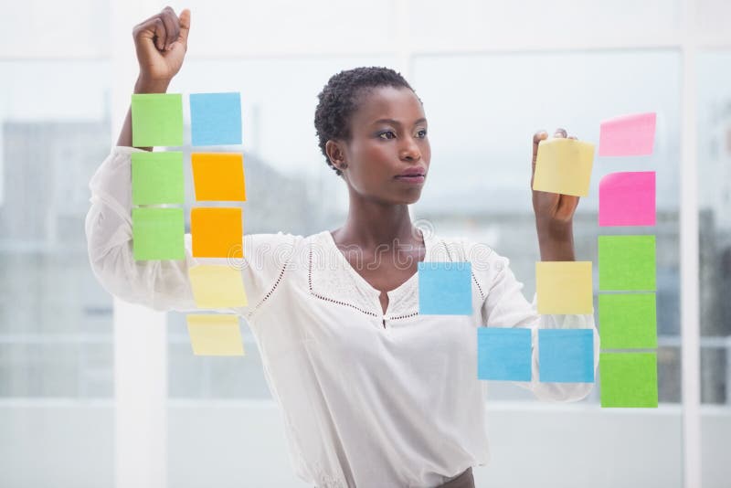 Creative Businesswoman Writing on Sticky Notes on Window Stock Image ...