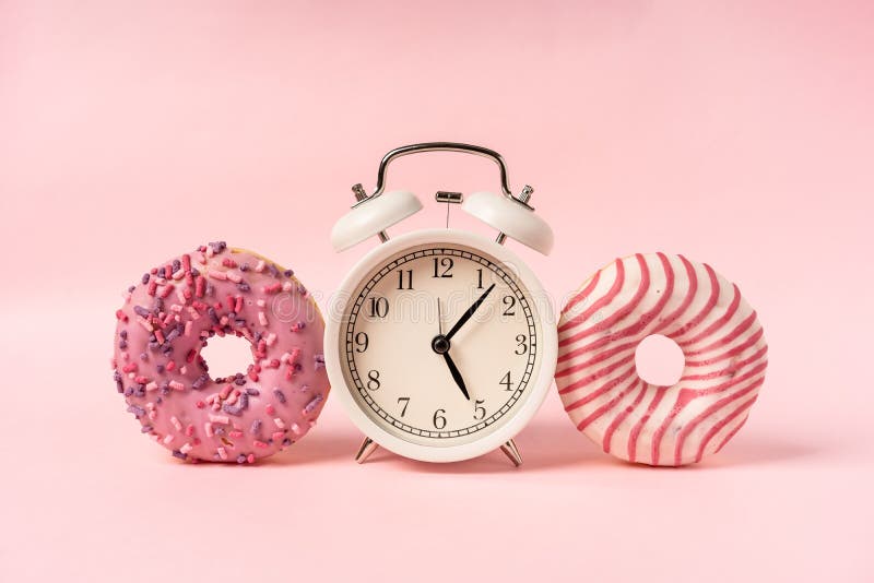 Creative Composition of Two Donuts and an Alarm Clock on a Pink ...