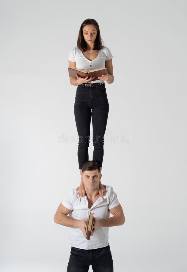 Creative Composition of Woman Standing on Man`s Shoulders and Reading ...