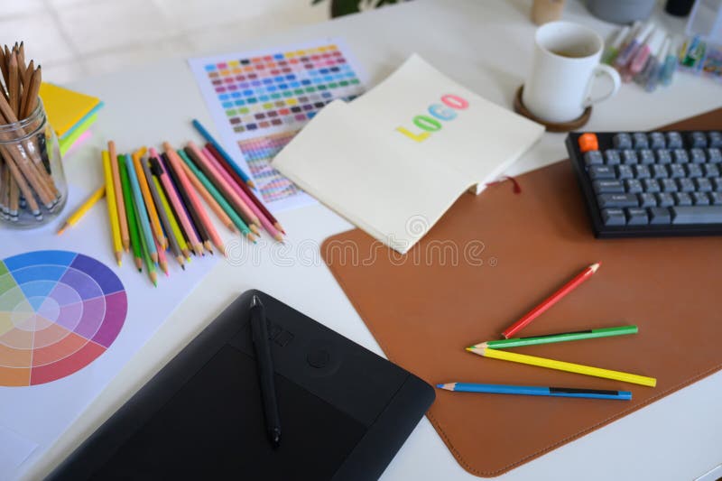 Creative Graphic Designer Workspace with Digital Drawing Tablet, Color Palette, and Notebook for ...