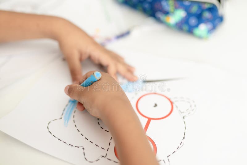 A Creative Kid Coloring the Shapes in Coloring Book with Pencil ...