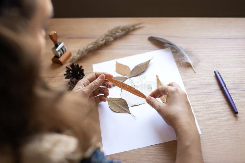 Person Crafting with Leaves and Paper on Wooden Table Stock Image ...