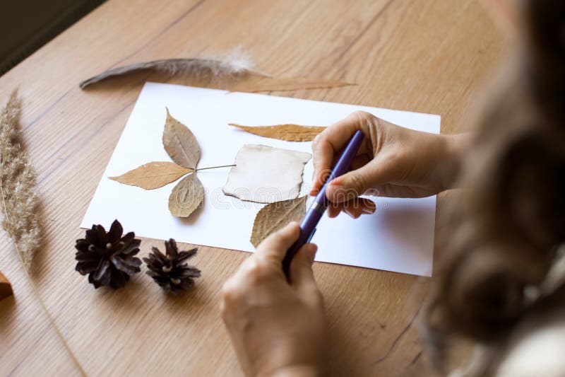 Person Crafting with Leaves and Paper on Wooden Table Stock Image ...