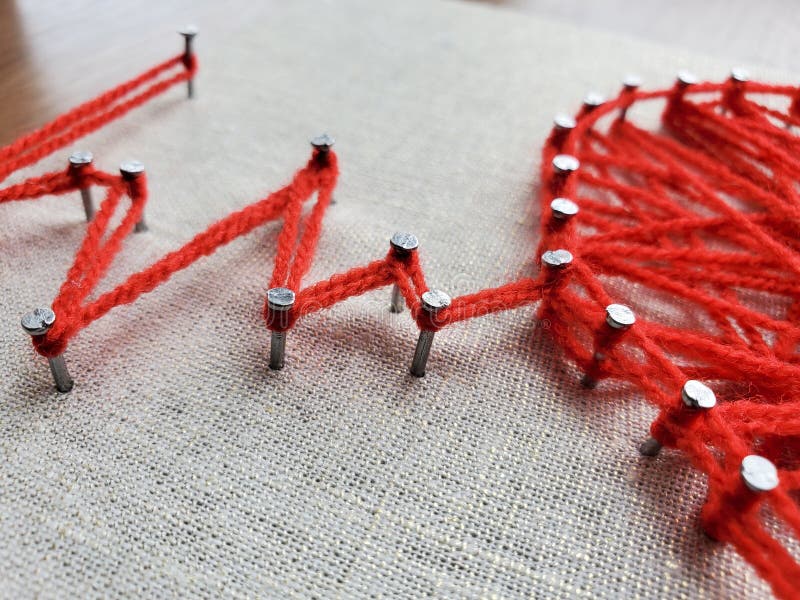 Creative String Art Project Featuring Vibrant Red Yarn and Nails on ...