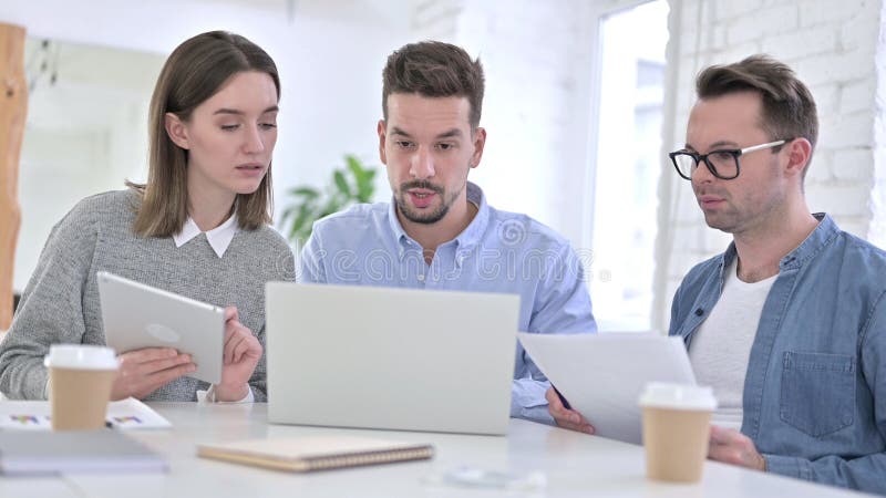 Creative Team Busy Working on Laptop, Documents and Tablet Stock Photo ...