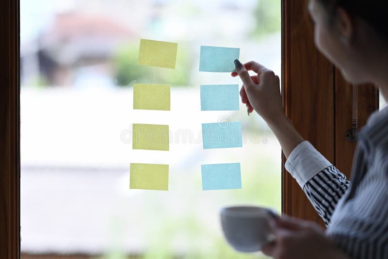 Woman Golding Coffee Cup and Writing Ideas on Sticky Notes on Glass ...
