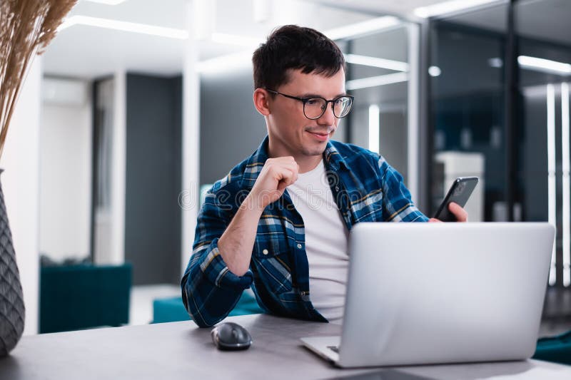 Creative Worker. Cheerful Young Man Using His Mobile Phone while ...