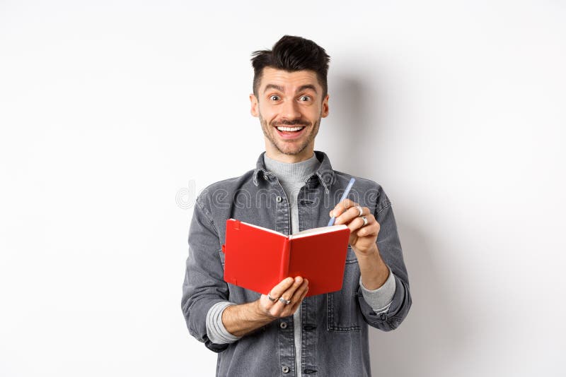Creative Young Man Smiling Excited while Taking Notes, Writing Down ...