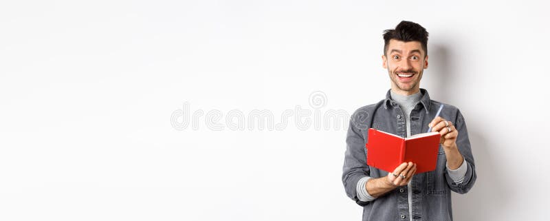 Creative Young Man Smiling Excited while Taking Notes, Writing Down ...