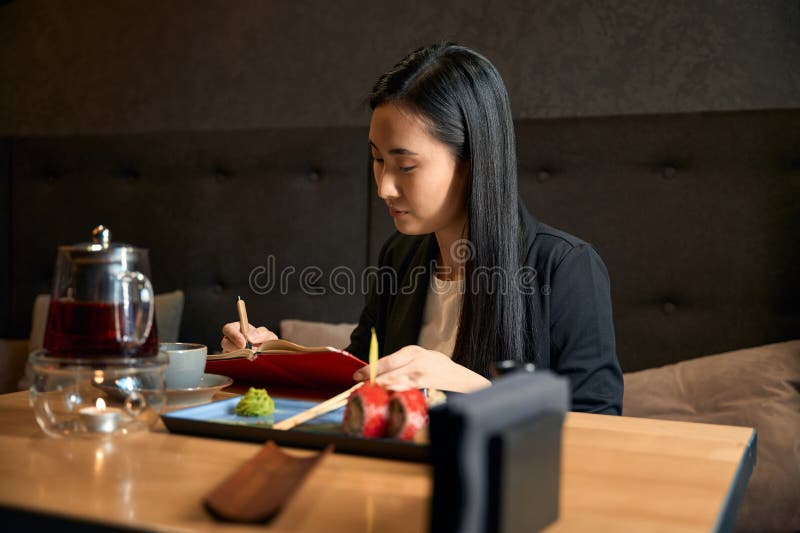 Creative Young Woman Making Notes in Her Notebook at Japanese ...