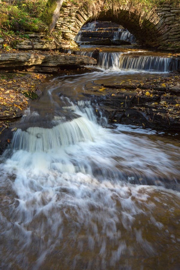 Creek with Waterfalls and an Old Arch Bridge Stock Image - Image of ...