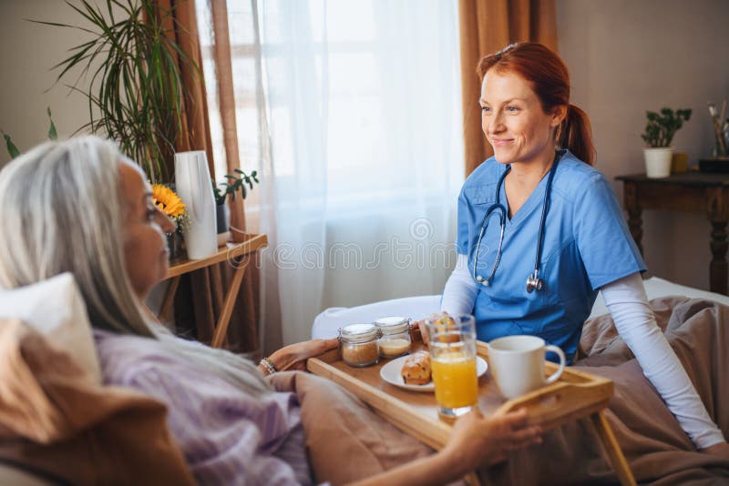 Cregiver Prepared Breakfast for Her Senior Client in the Bed. Stock ...