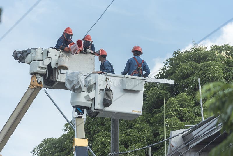 A Crew of Linemen Working on a Power Line, Installing Insulating Guards ...
