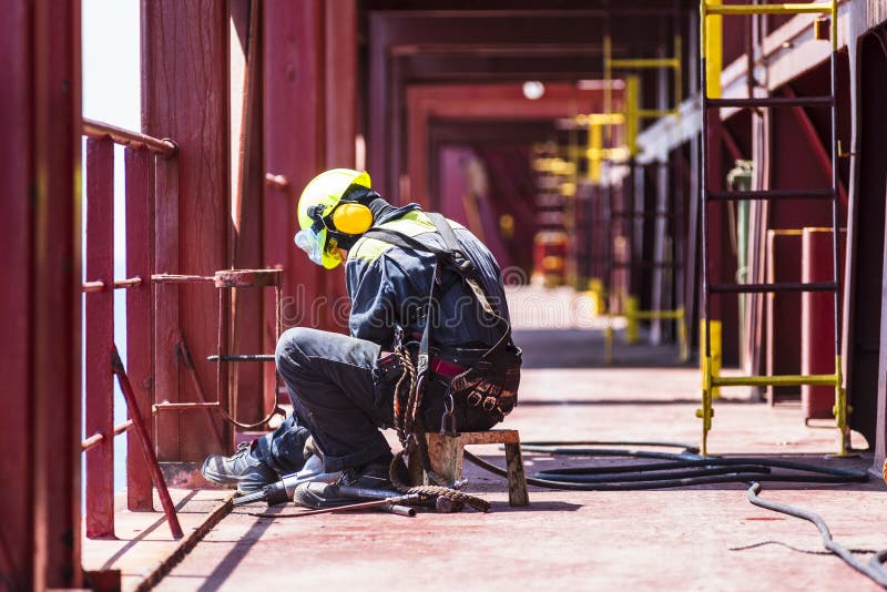 A Crew Member Working on the Deck of a Merchant Ship, Using a Pneumatic Tool To Remove Rust ...