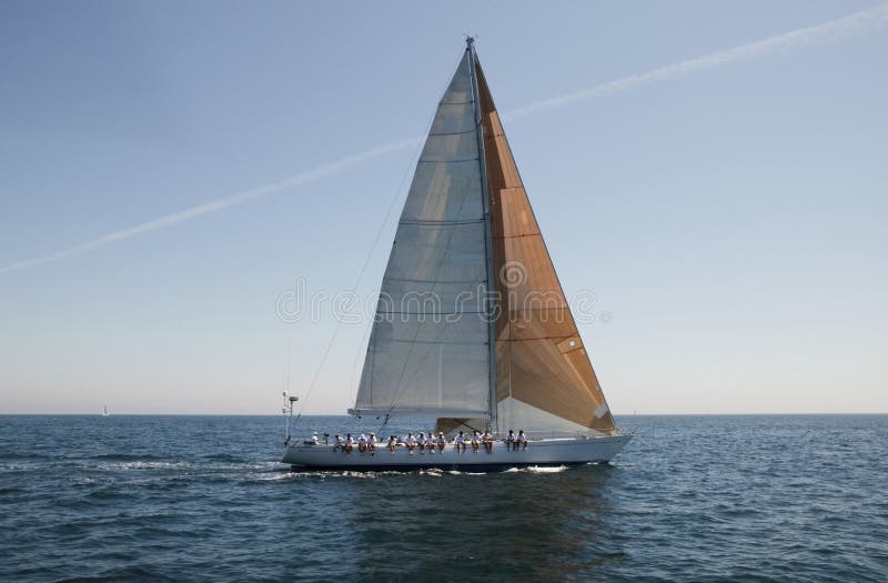 Crew Members Sitting on the Side of a Sailboat in the Ocean Stock Image ...