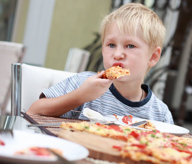 A criança come a pizza. imagem de stock. Imagem de lanche - 23854733